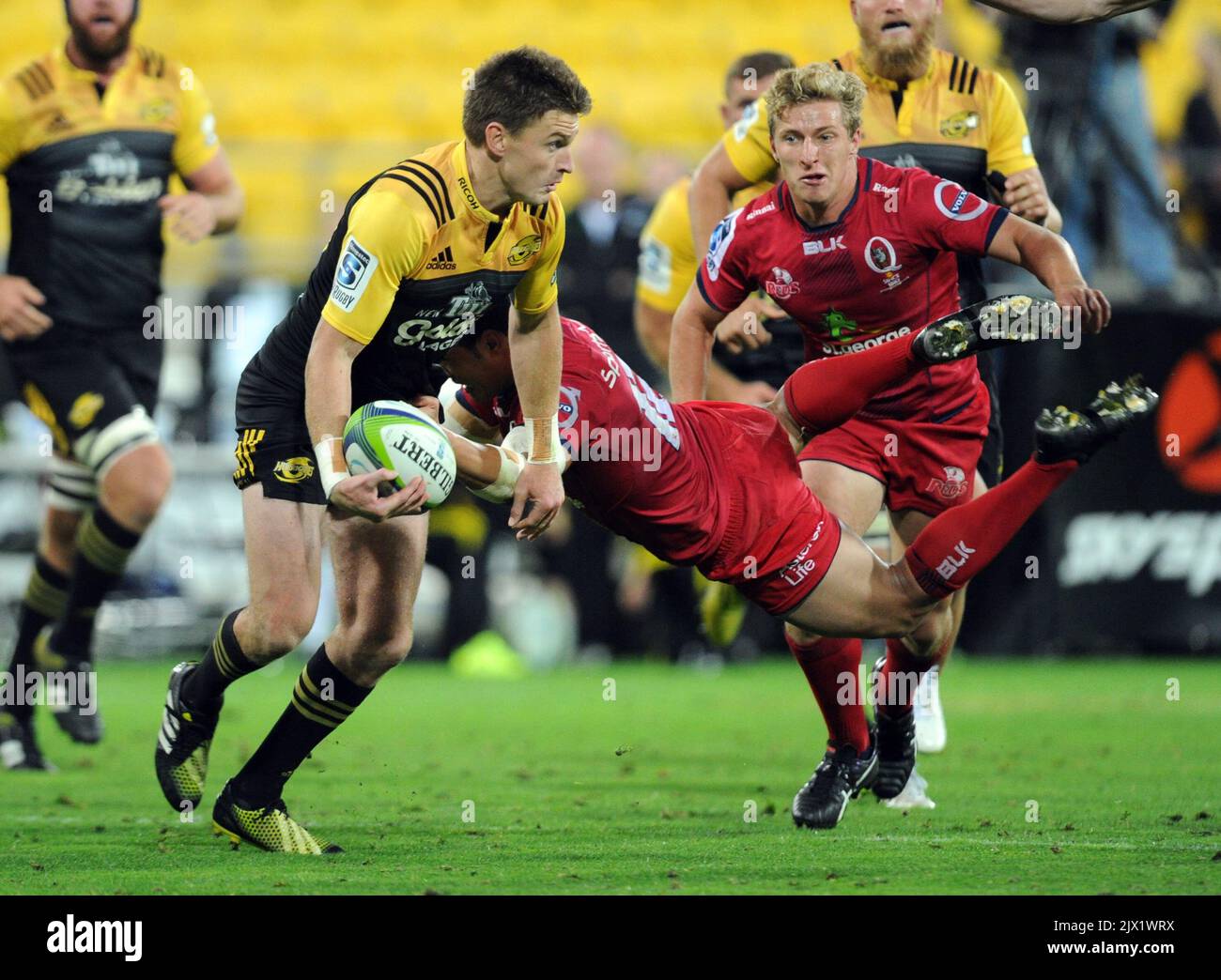 Beauden Barrett of the Hurricanes is tackled by a diving Anthony ...