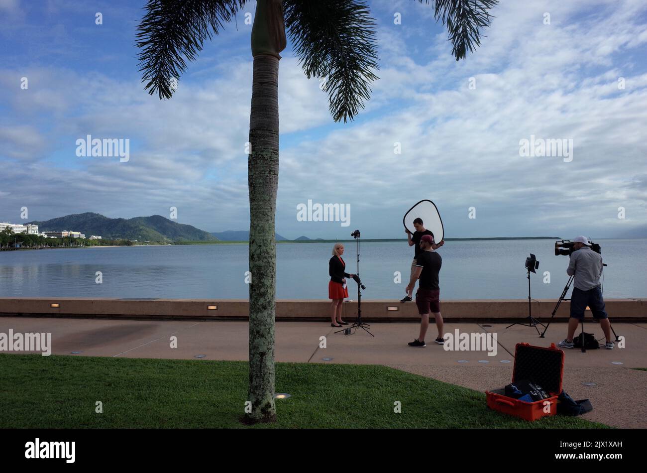 A TV crew is seen during a live cross for morning TV in Cairns ...