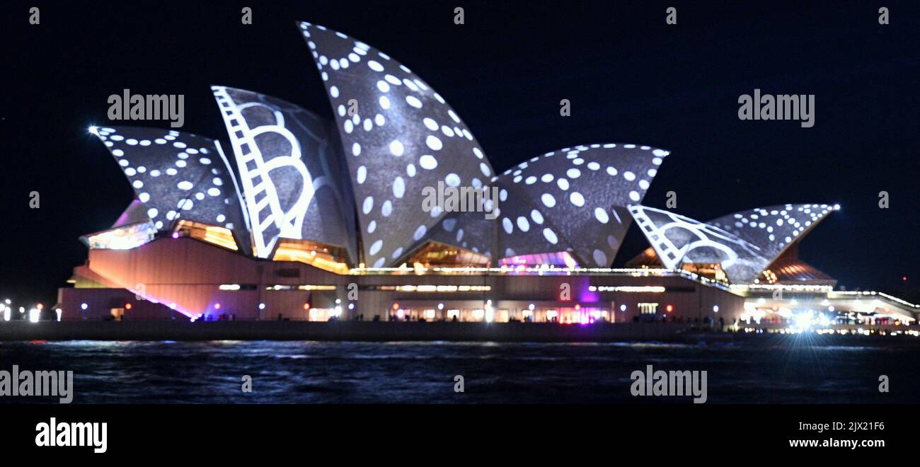 The sails on the Sydney Opera House are seen lit with an art ...