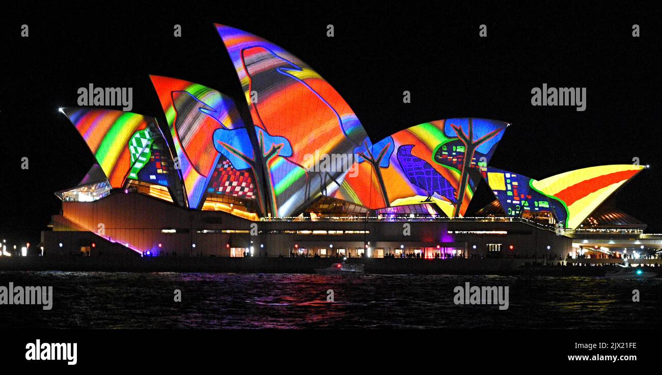 The sails on the Sydney Opera House are seen lit with an art ...