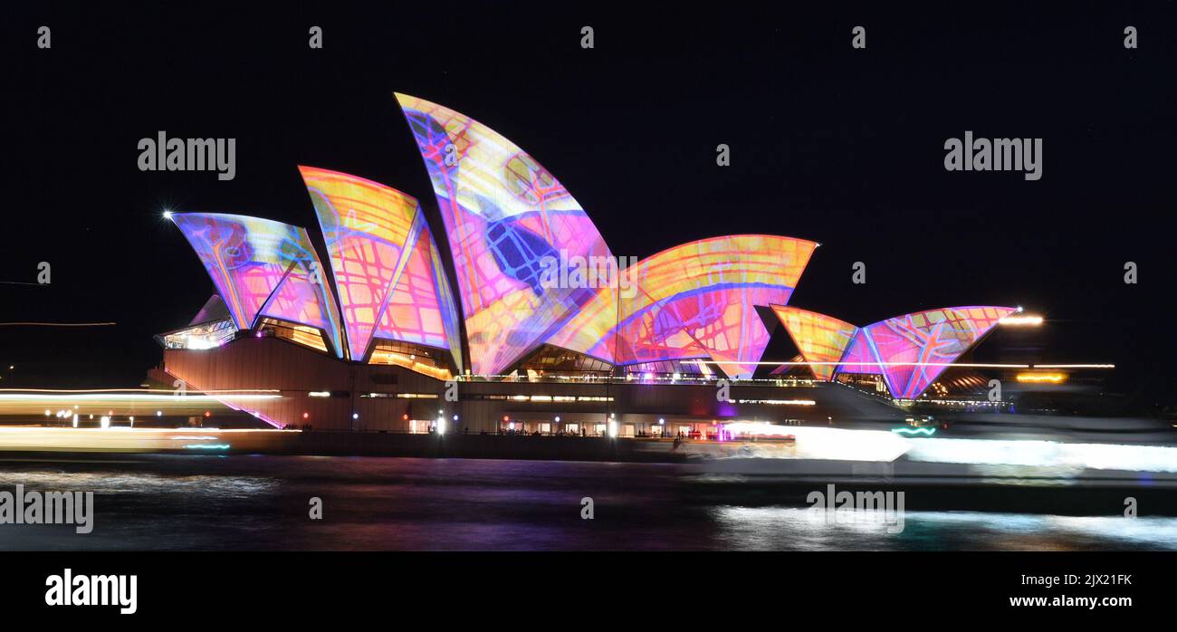 The sails on the Sydney Opera House are seen lit with an art ...