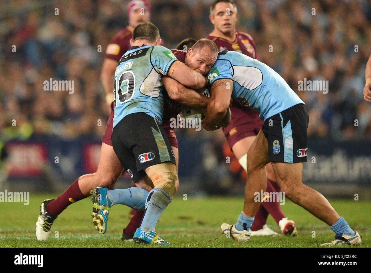Matt Scott of the Maroons is tackled by James Tamou and Paul Gallen of ...