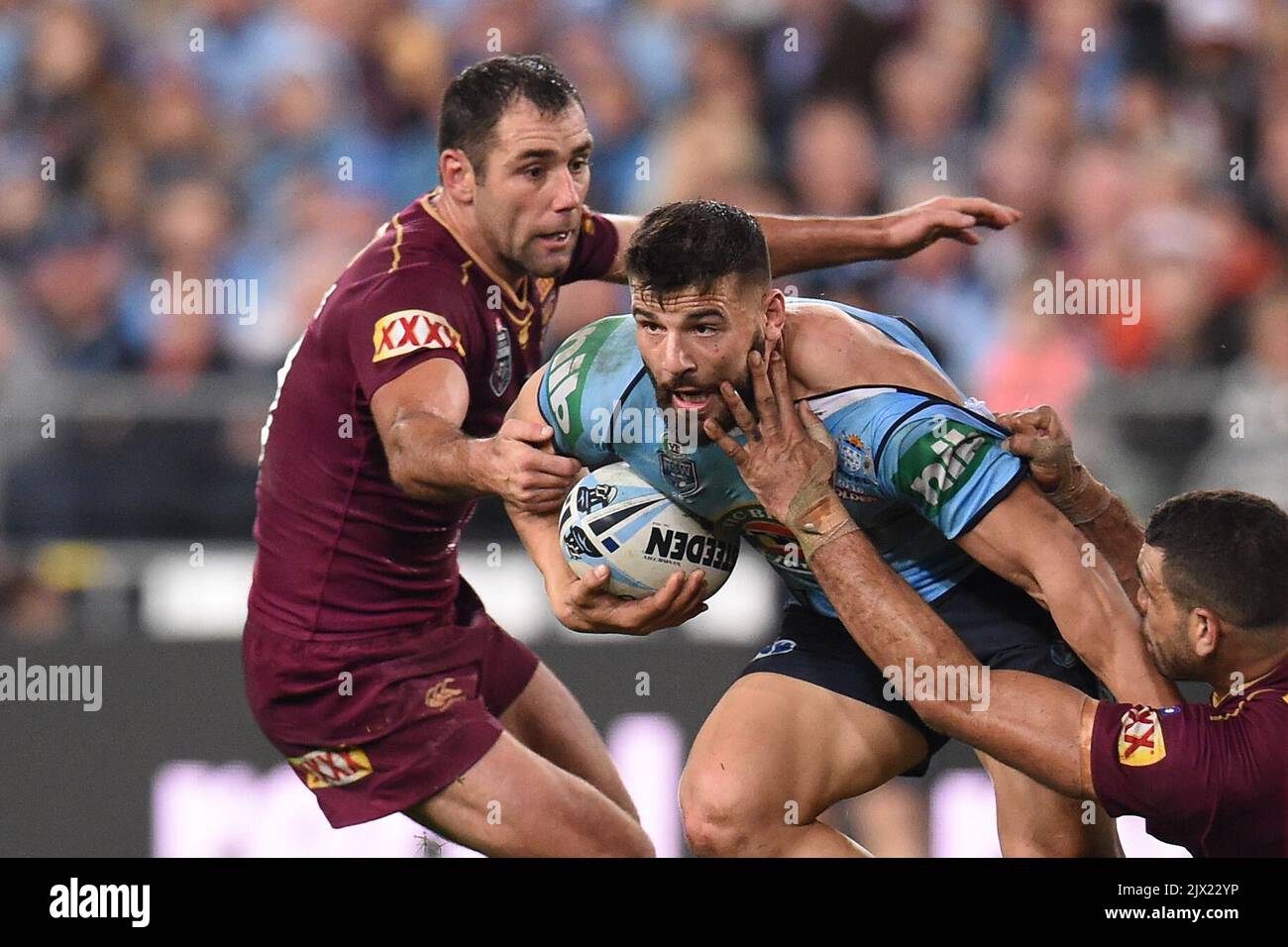 Josh Mansour of the Blues is tackled by Greg Inglis and Cameron Smith ...