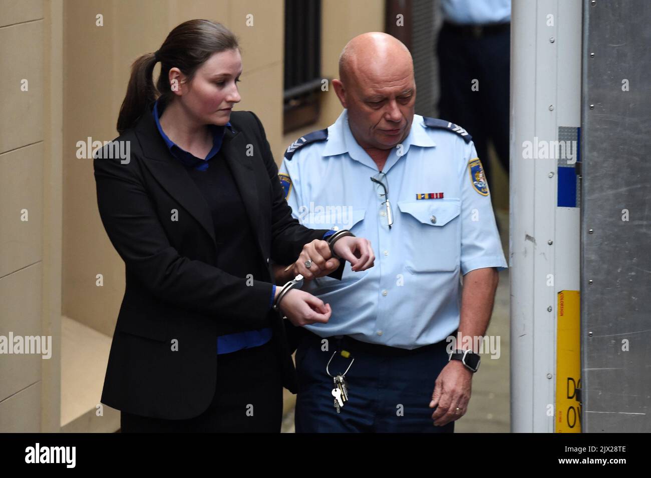 Harriet Wran (left) is escorted to a prison transport vehicle at the NSW Supreme Court in Sydney ...
