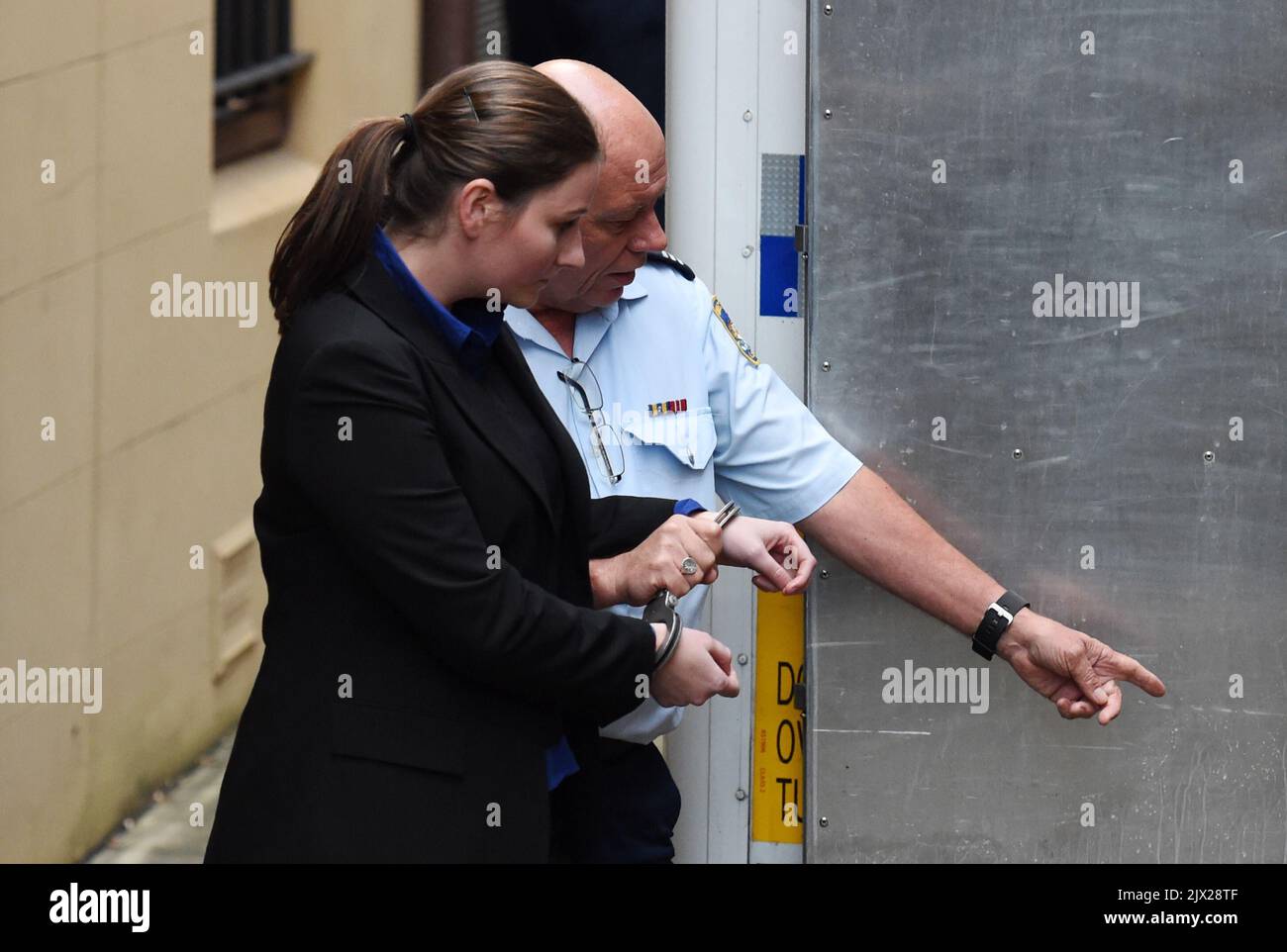 Harriet Wran (left) is escorted to a prison transport vehicle at the NSW Supreme Court in Sydney ...