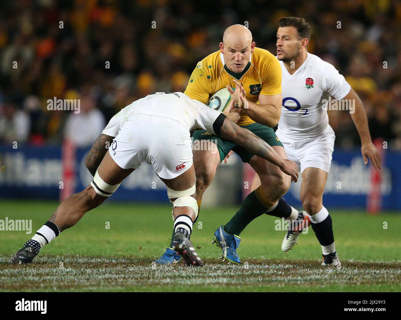 Stephen Moore of Australia runs with the ball into the England defence ...
