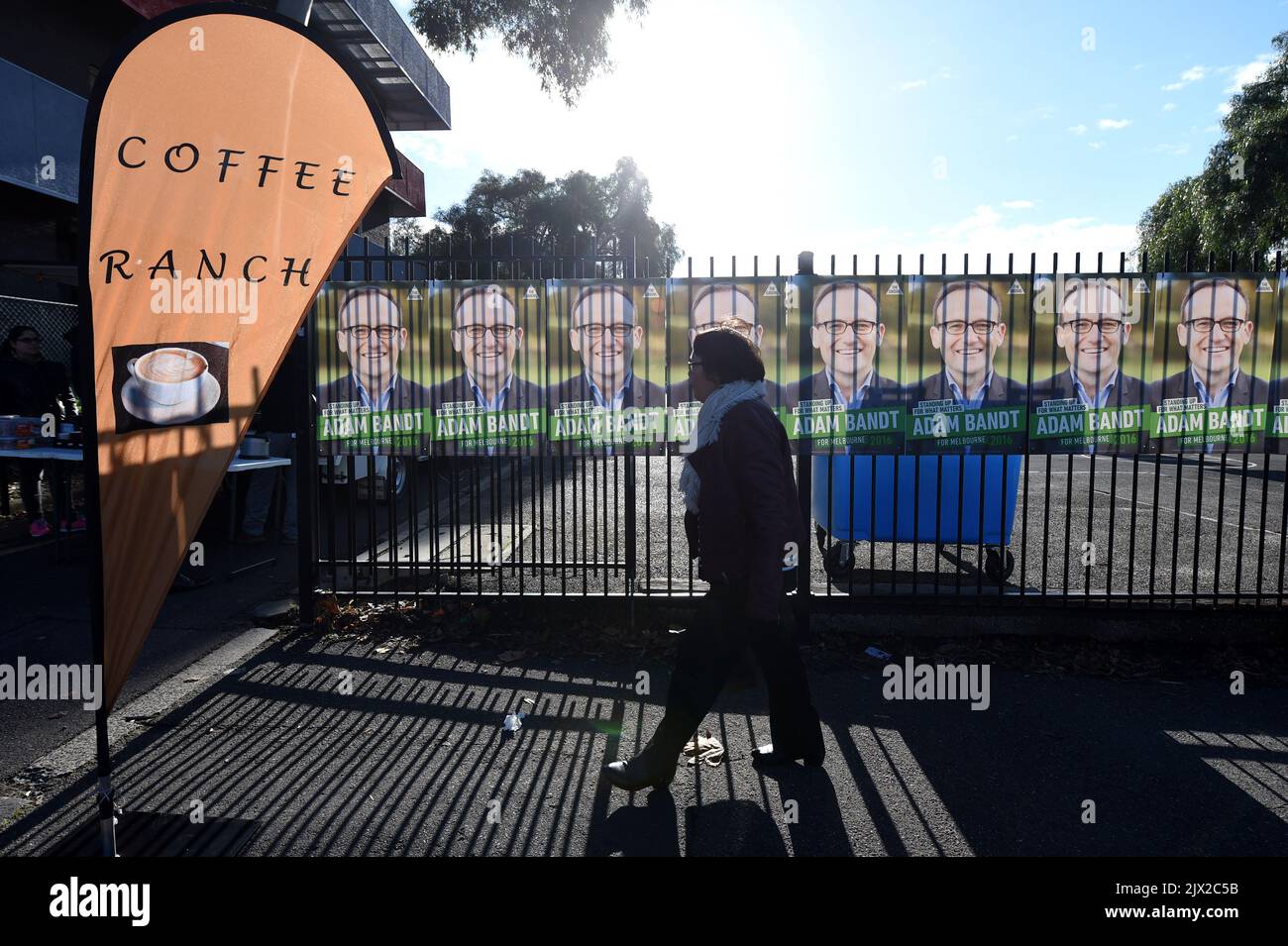 Voters walk past posters for Greens Adam Bandt at Mount Alexander ...