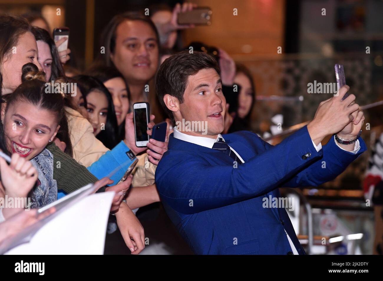 American actor Adam Devine (right) poses for photographs with fans ...