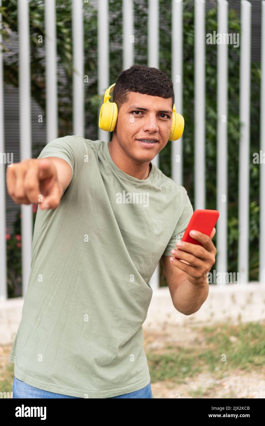 Latin Man In Headphones Using Mobile Phone At City Street Stock Photo ...