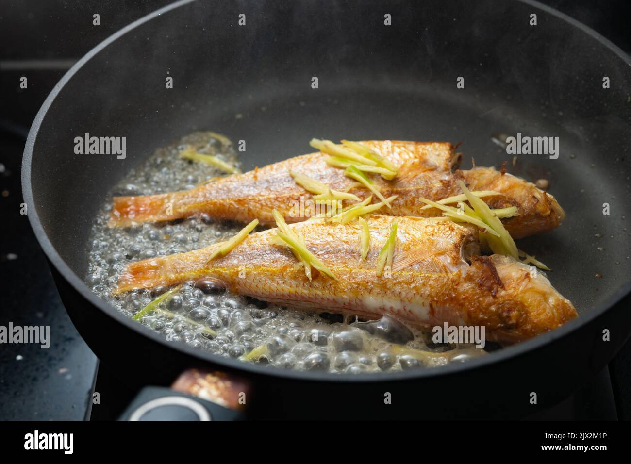 frying fishes by a pan Stock Photo - Alamy