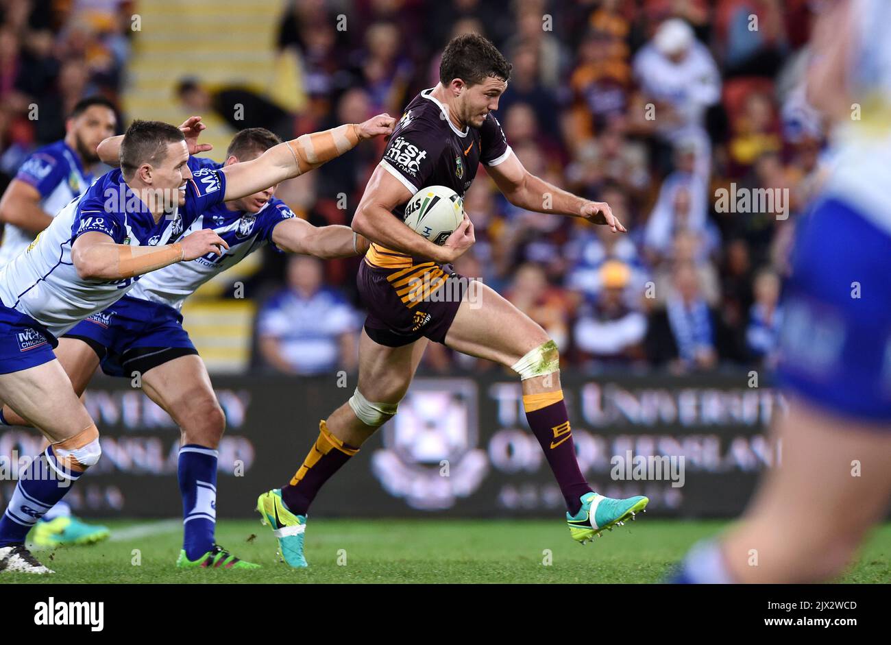 Corey Oats of the Brisbane Broncos (centre) gains ground during their ...