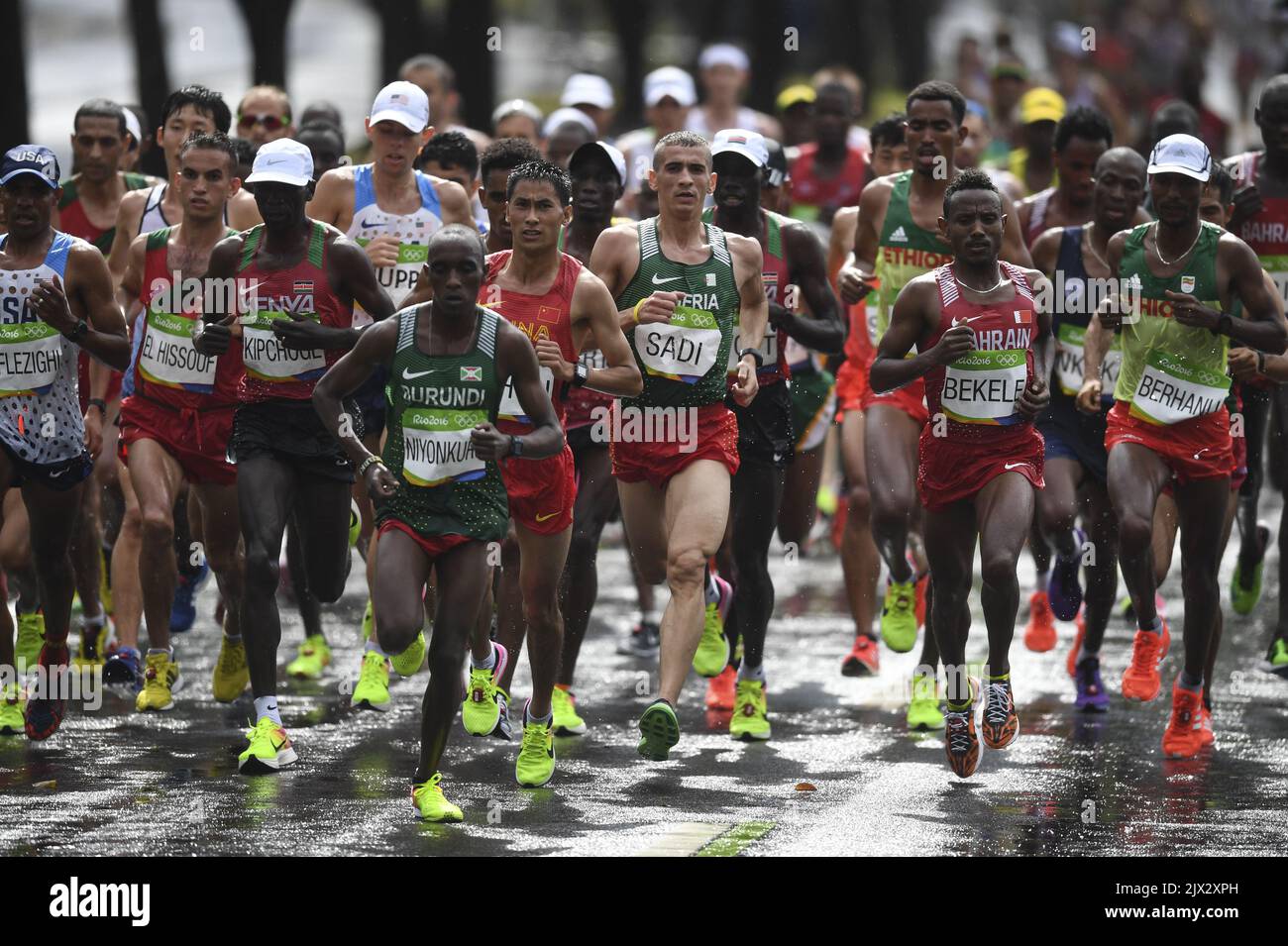 Competitors are seen running during the Men's Marathon on day sixteen ...