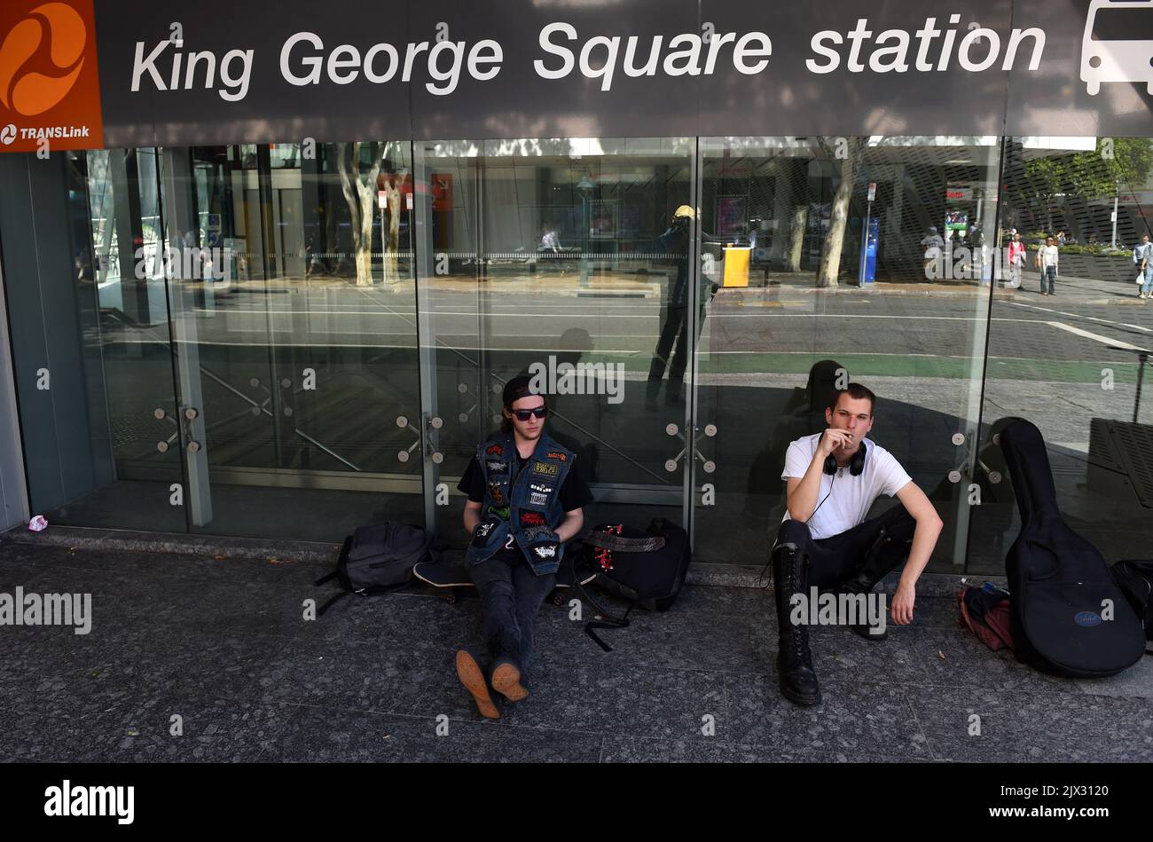 Storm Williams (right) smokes outside the entrance to a train station ...