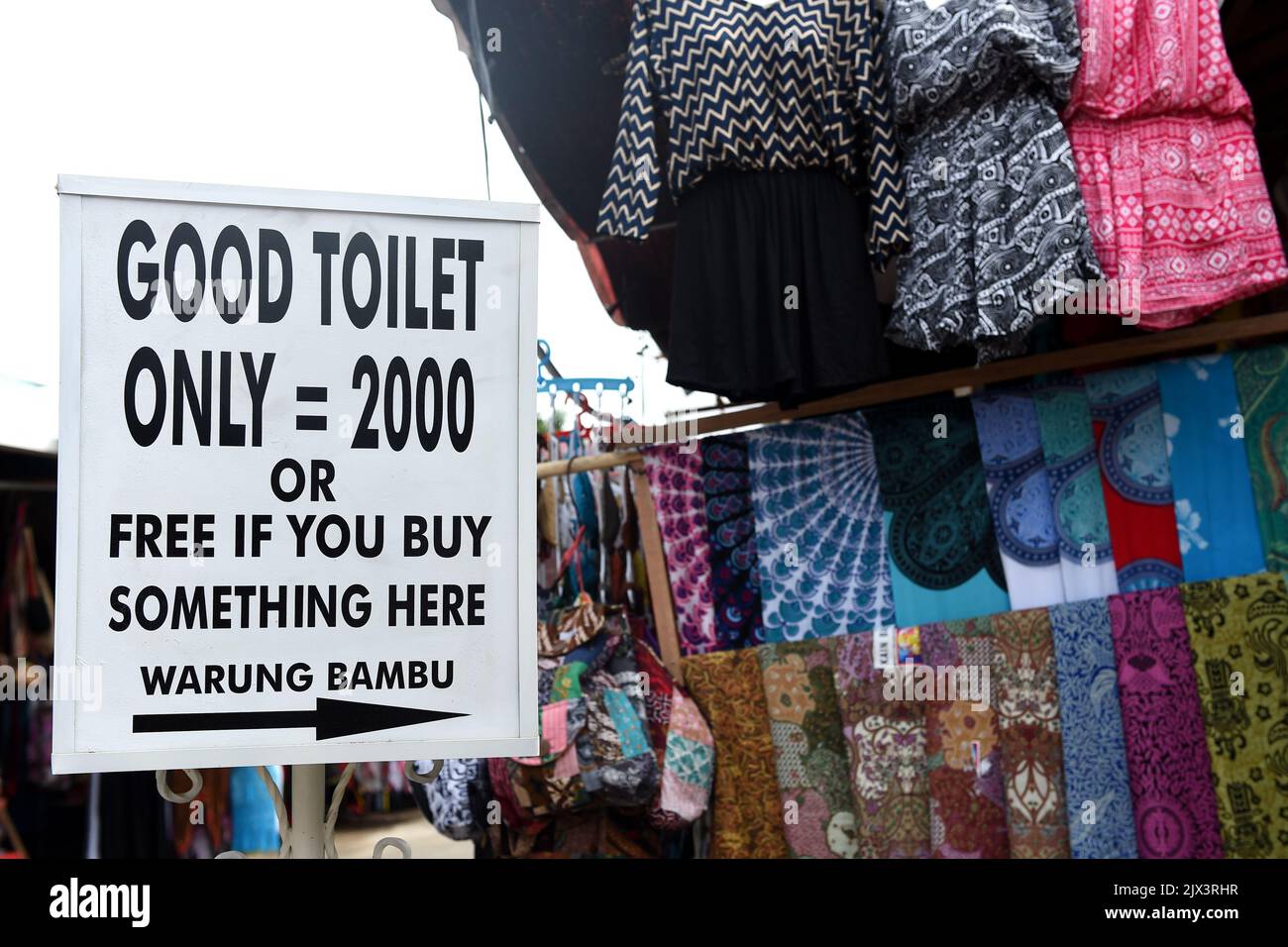 A sign advertising a toilet lines the walkway leading to Tegenungan ...