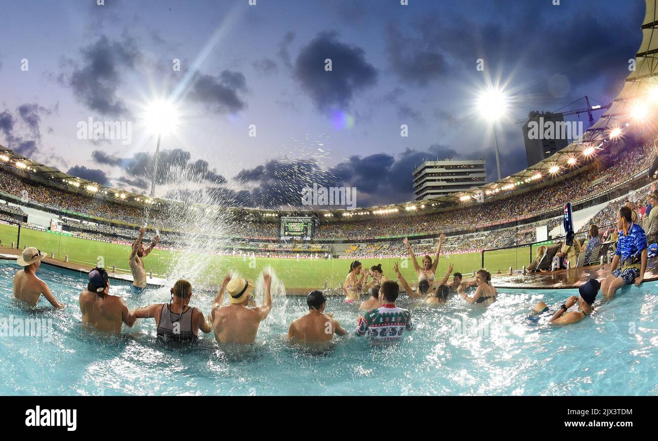 Spectators look on from a boundary swimming pool at sunset on day 1 of ...