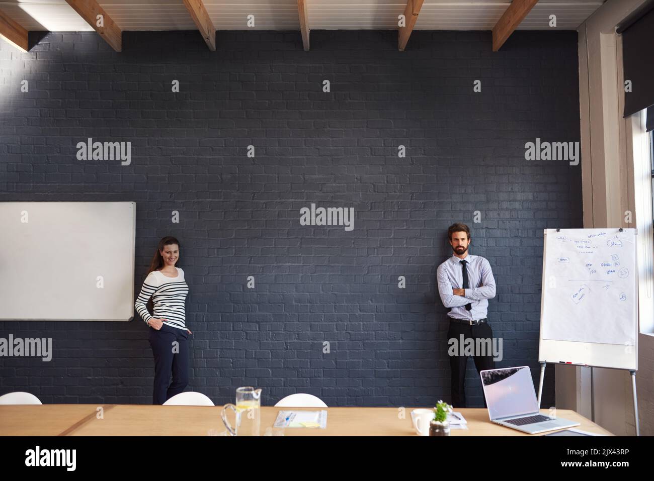Double presentation. Portrait of two young businesspeople standing in ...