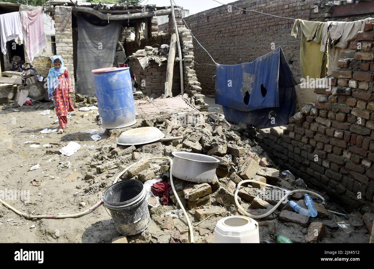 Nowshera. 6th Sep, 2022. A girl is seen in her partially damaged house ...