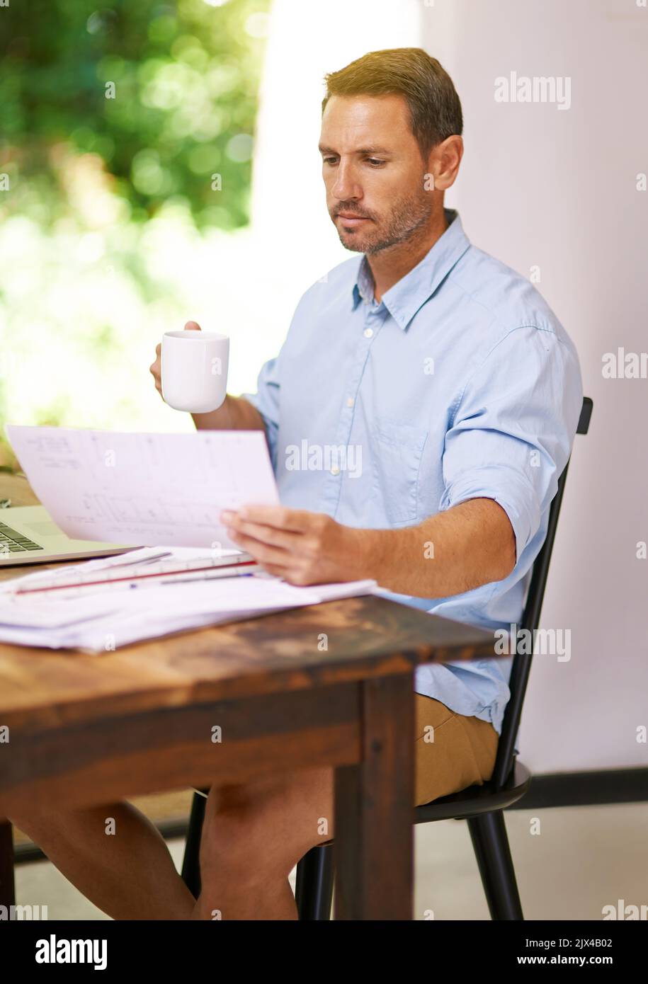 Taking care of a little admin. a young man working from home Stock ...