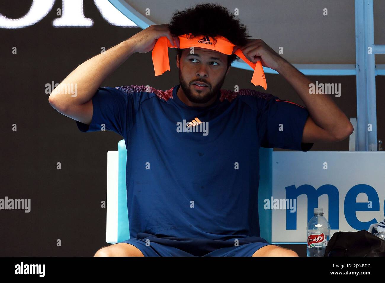 Jo-Wilfried Tsonga of France ties his bandana during the Mens Singles ...