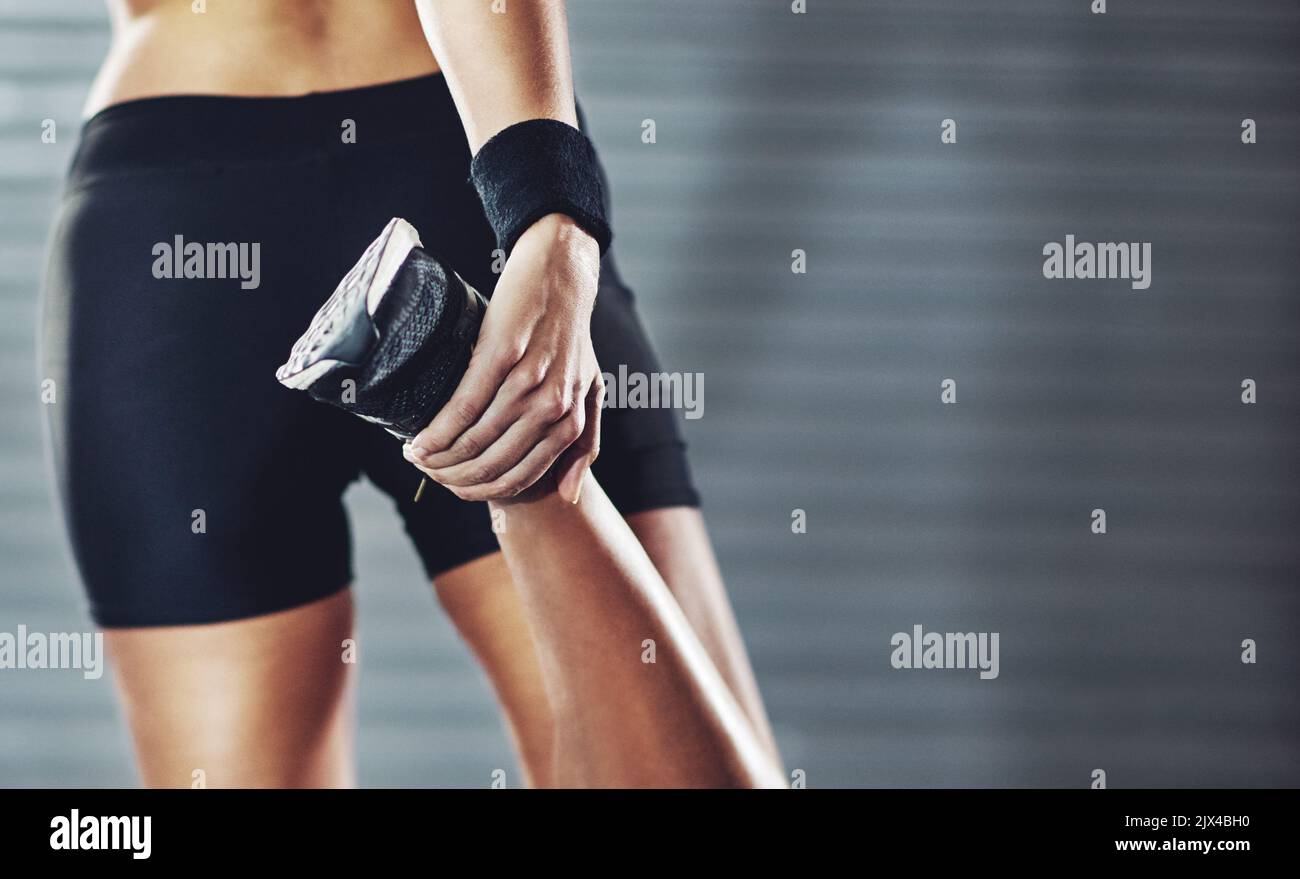 Preparing for some action. Cropped rearview shot of a woman stretching ...