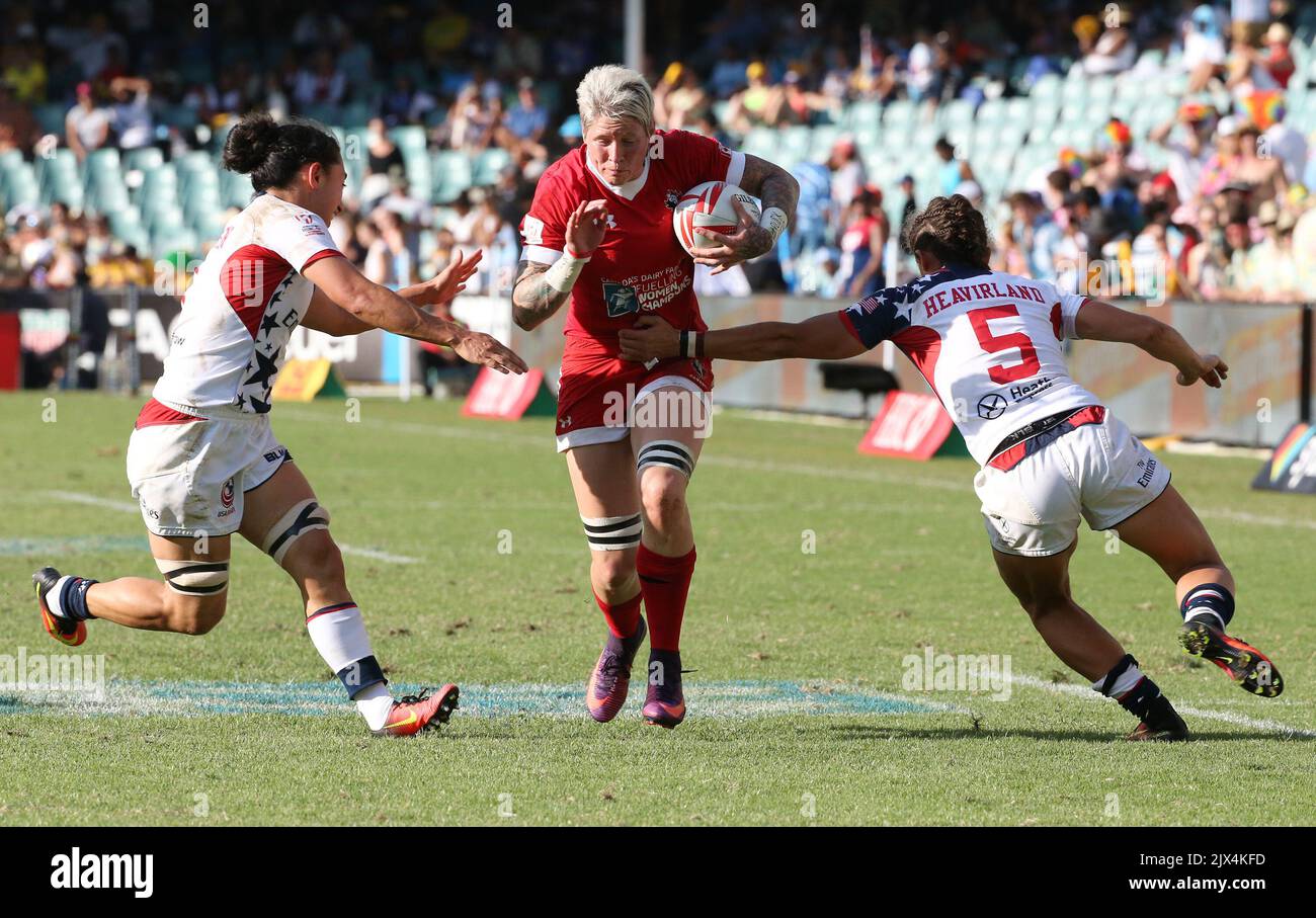 Canada's Jennifer Kish (centre) runs with the ball through the USA ...