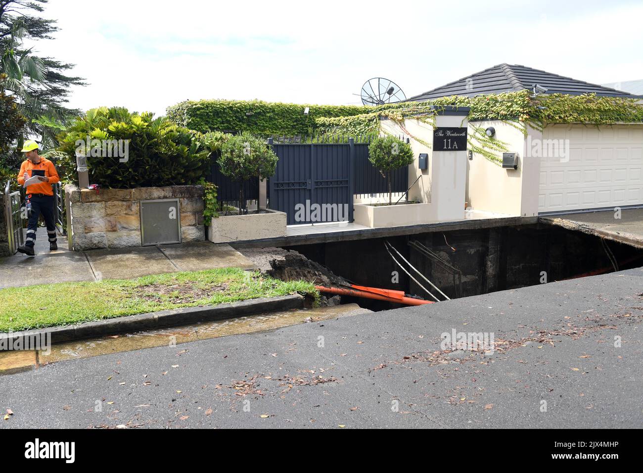 A workman leaves a property where a sinkhole has opened up in the ...