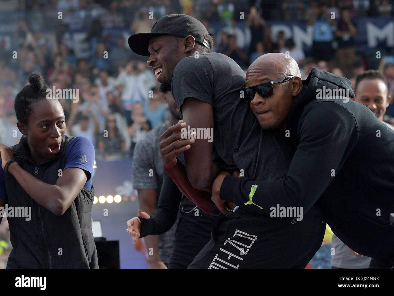 Jamaican sprinter Usain Bolt is hugged by Jamaican sprinter Asafa ...