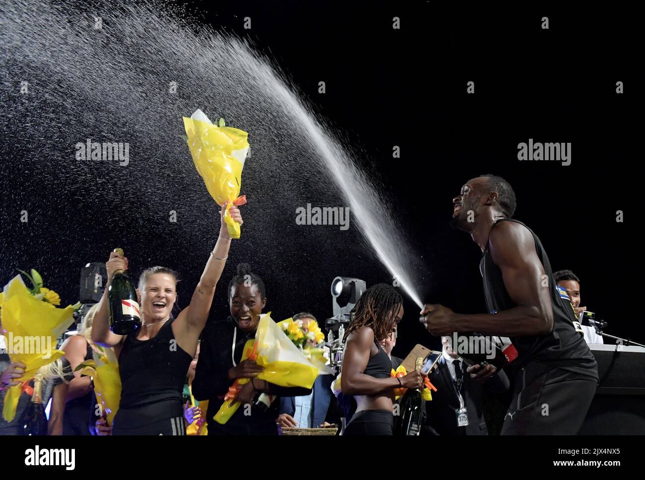 Jamaican sprinter Usain Bolt sprays a bottle of champagne on his team ...