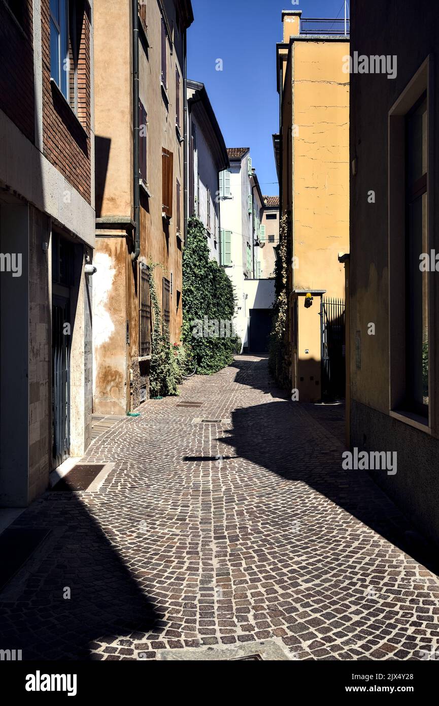 Narrow alley with tall buildings on a sunny day Stock Photo - Alamy