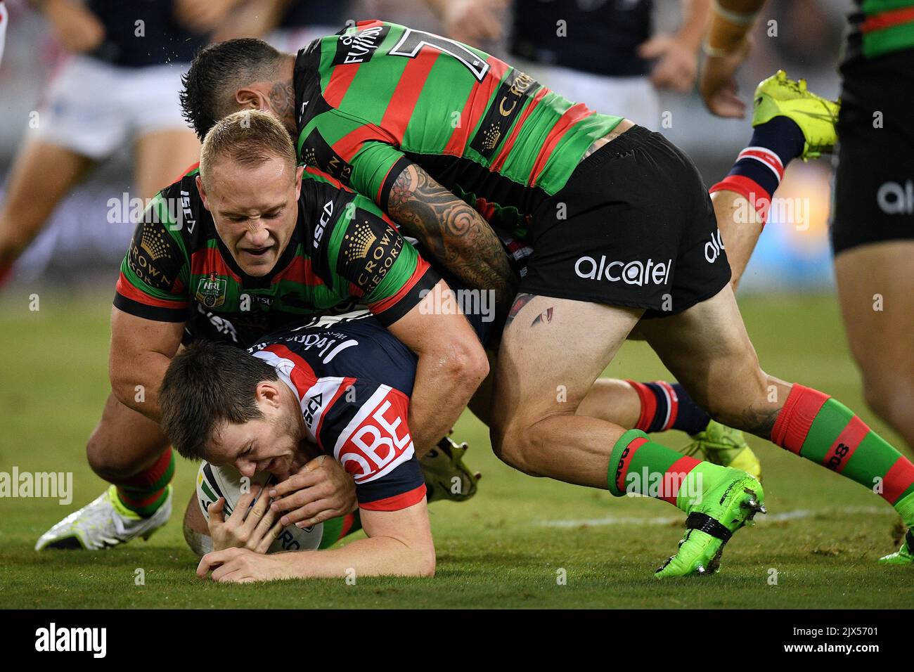 Luke Keary of the Roosters is tackled by Jason Clark, (left), and Adam ...