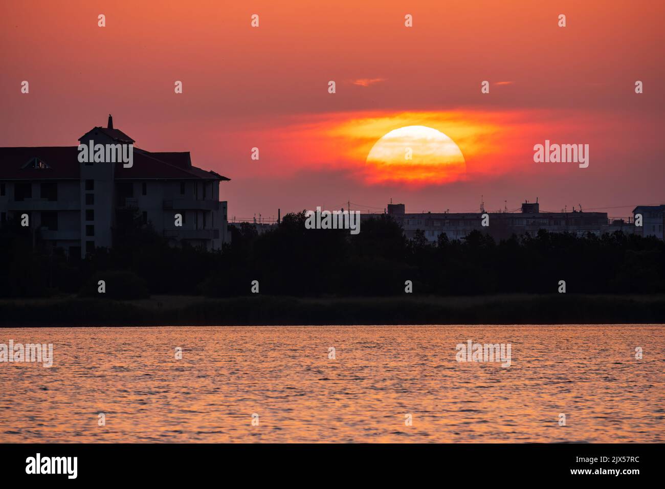 The sun goes down over a lake. Dramatic Sunset Sky Stock Photo - Alamy