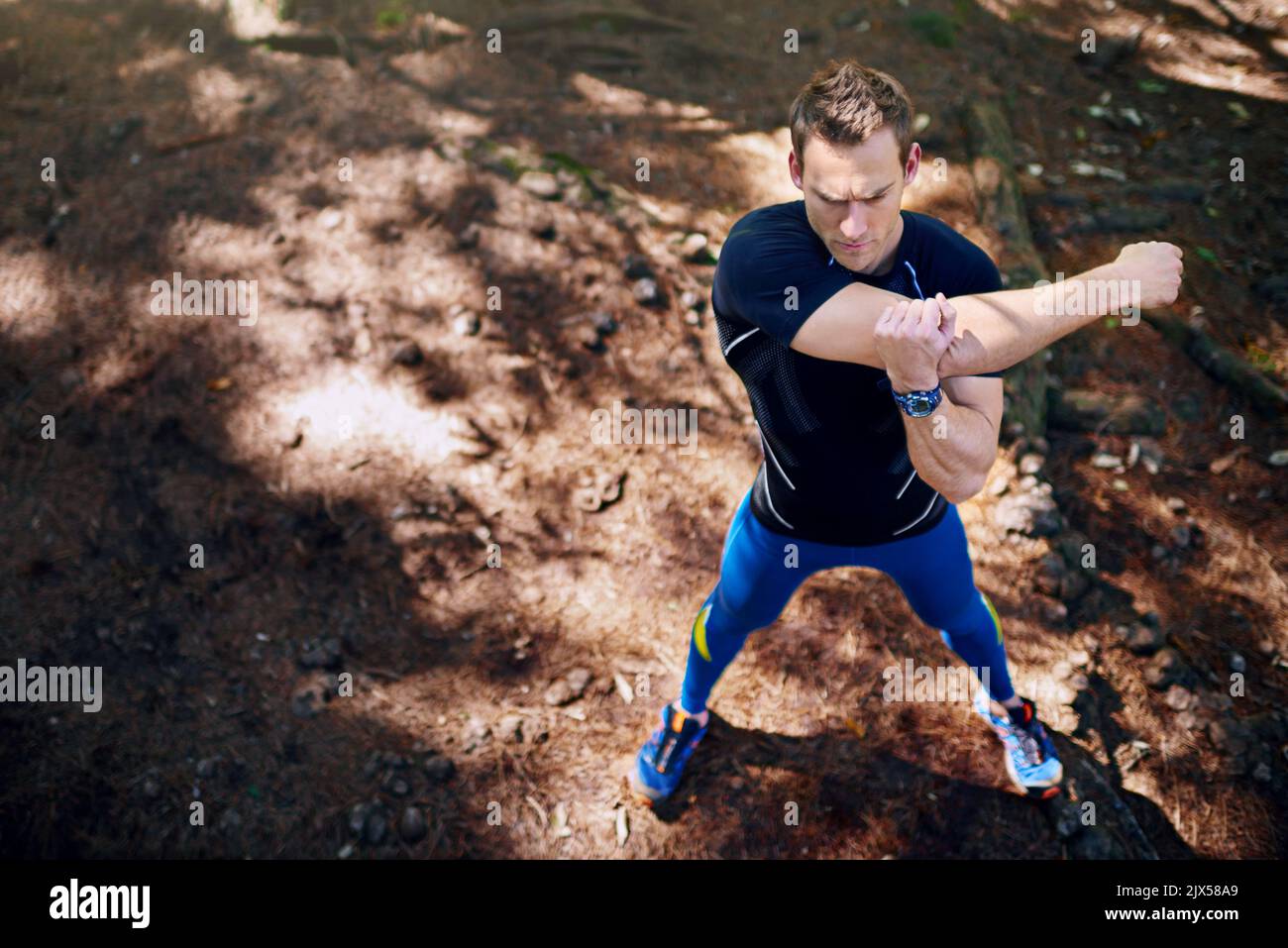 Getting in a good stretch before his run. a young man stretching before ...
