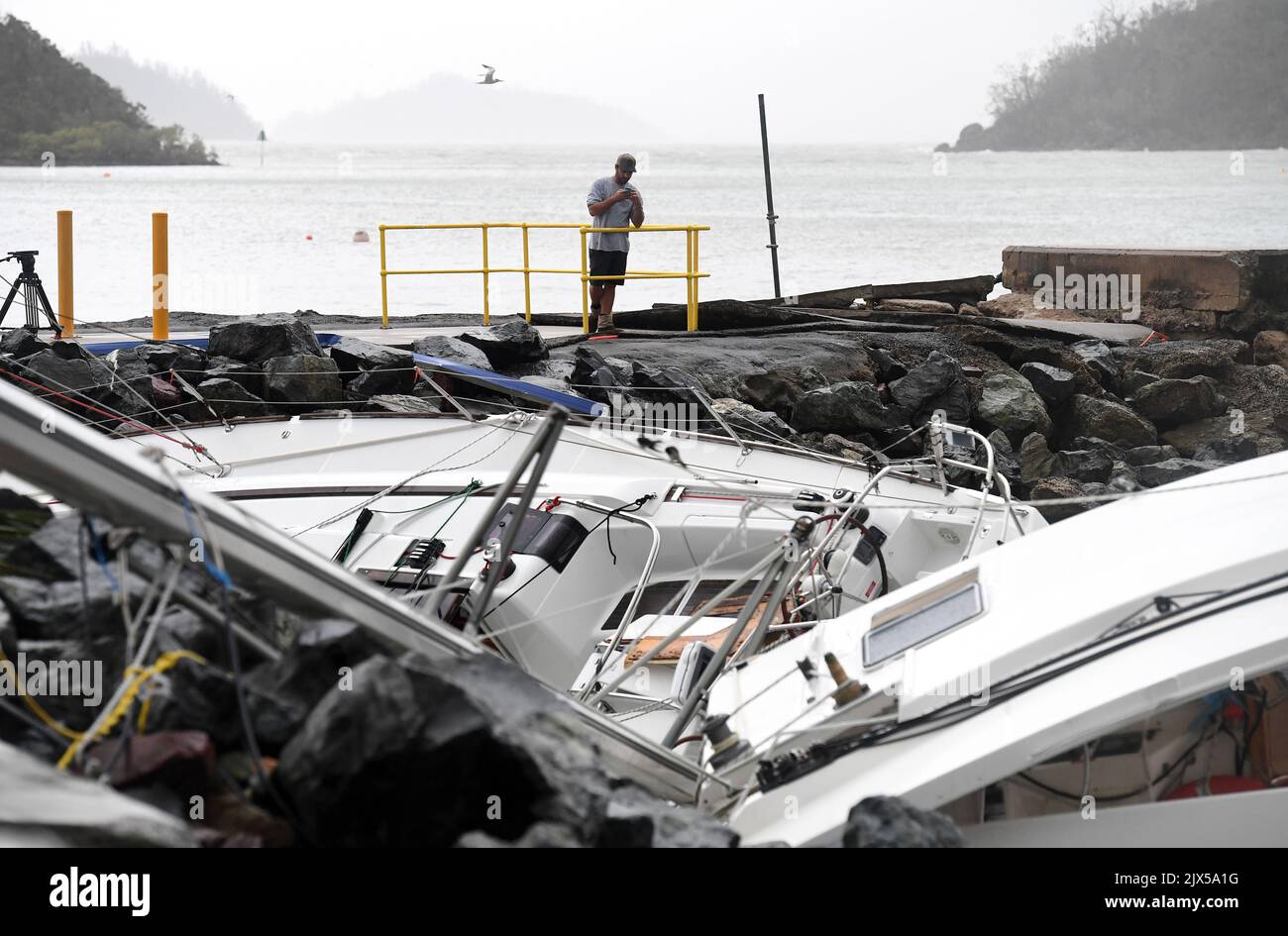 Boats are seen smashed against the rocks at Shute Harbour, near Airlie ...
