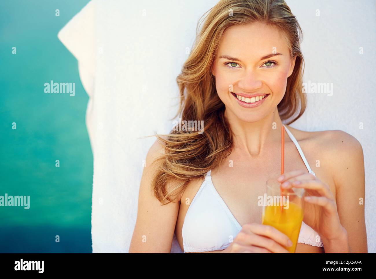 My summer vacation starts now. Portrait of an attractive young woman enjoying a poolside drink ...