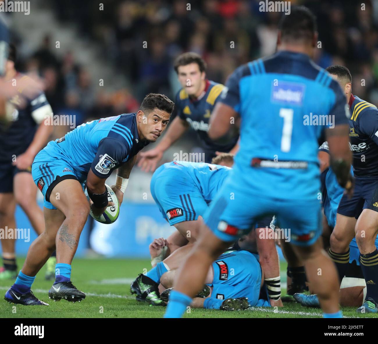 The Blues' Augustine Pulu, left, delivers a pass in the Super Rugby ...