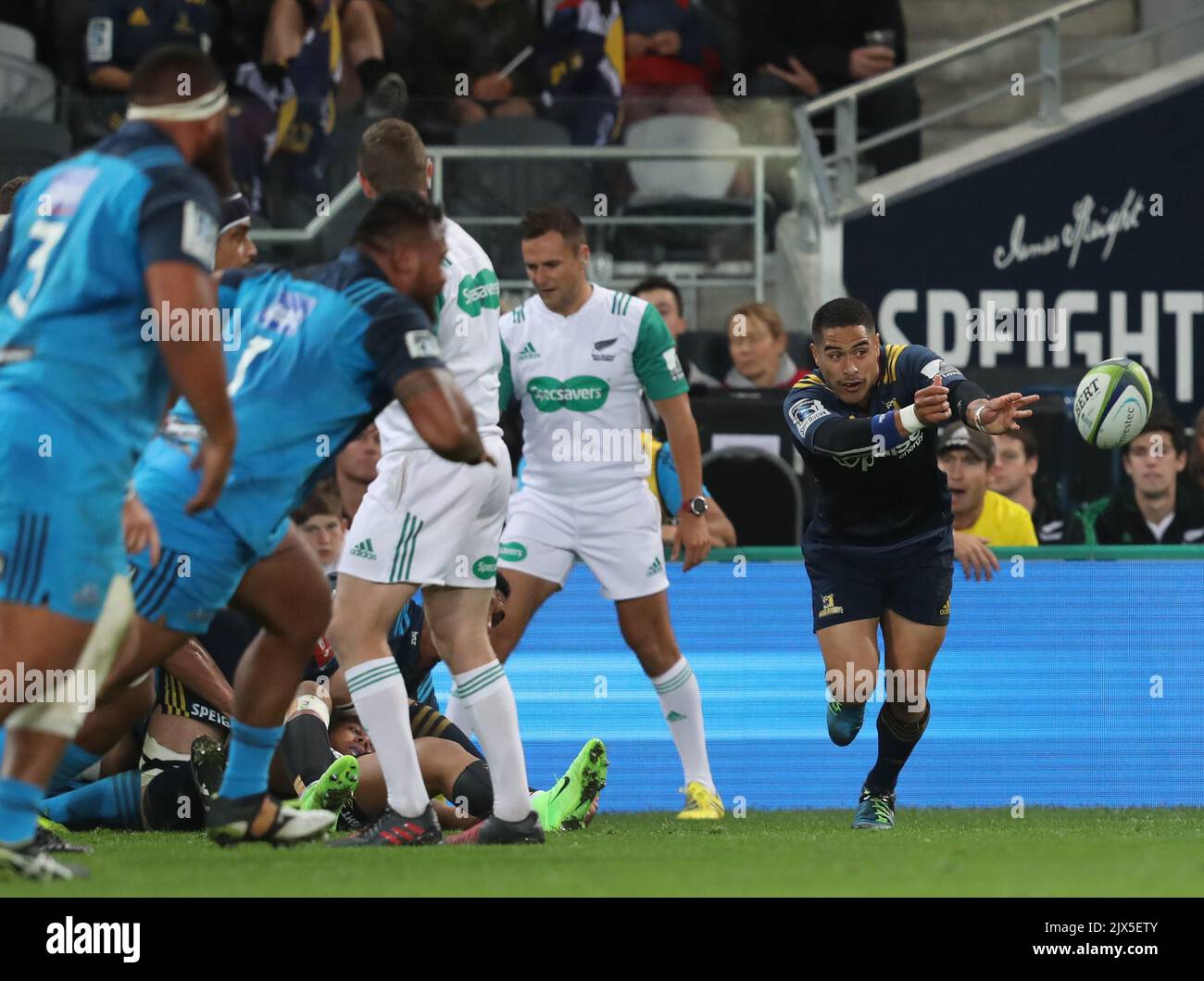 The Highlanders' Aaron Smith, right, delivers a pass in the Super Rugby ...