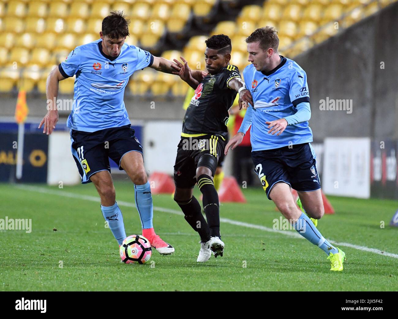 Roy Krishna of the Phoenix, centre, is squeezed by Filip Holosko of the ...