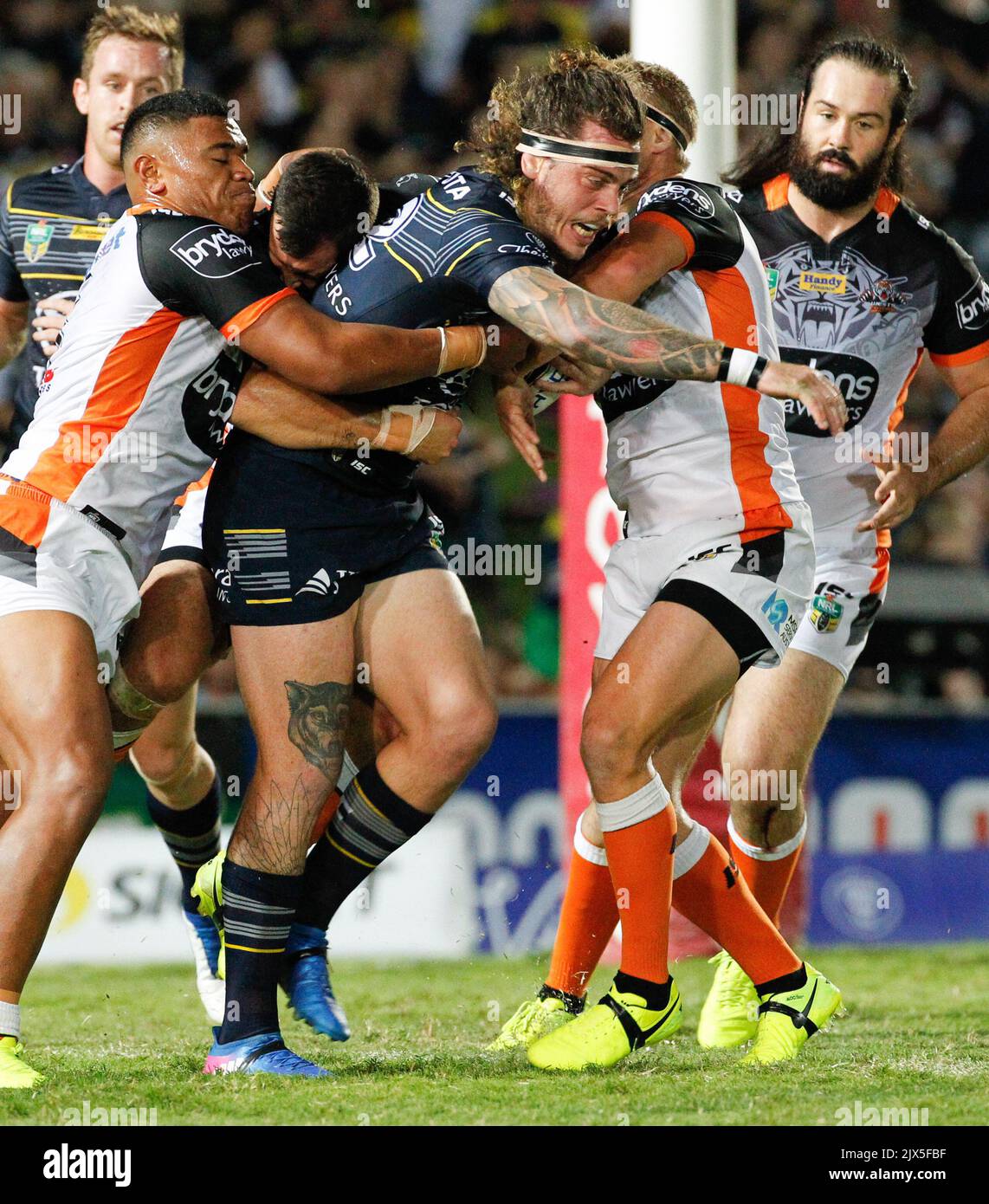Cowboys Ethan Lowe tackled by Tigers Mosese Suli, left, and Matt ...