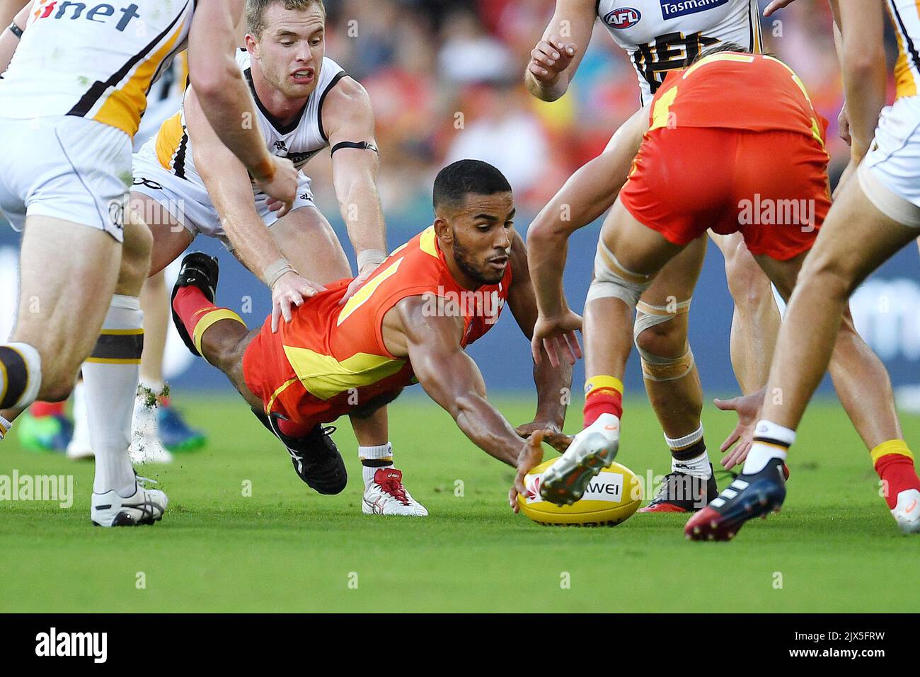 Touk Miller of the Gold Coast Suns (centre) dives for a ball during ...