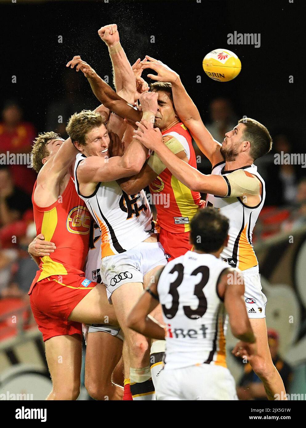 Gold Coast Suns and Hawthorn Hawks players fight for possession during ...