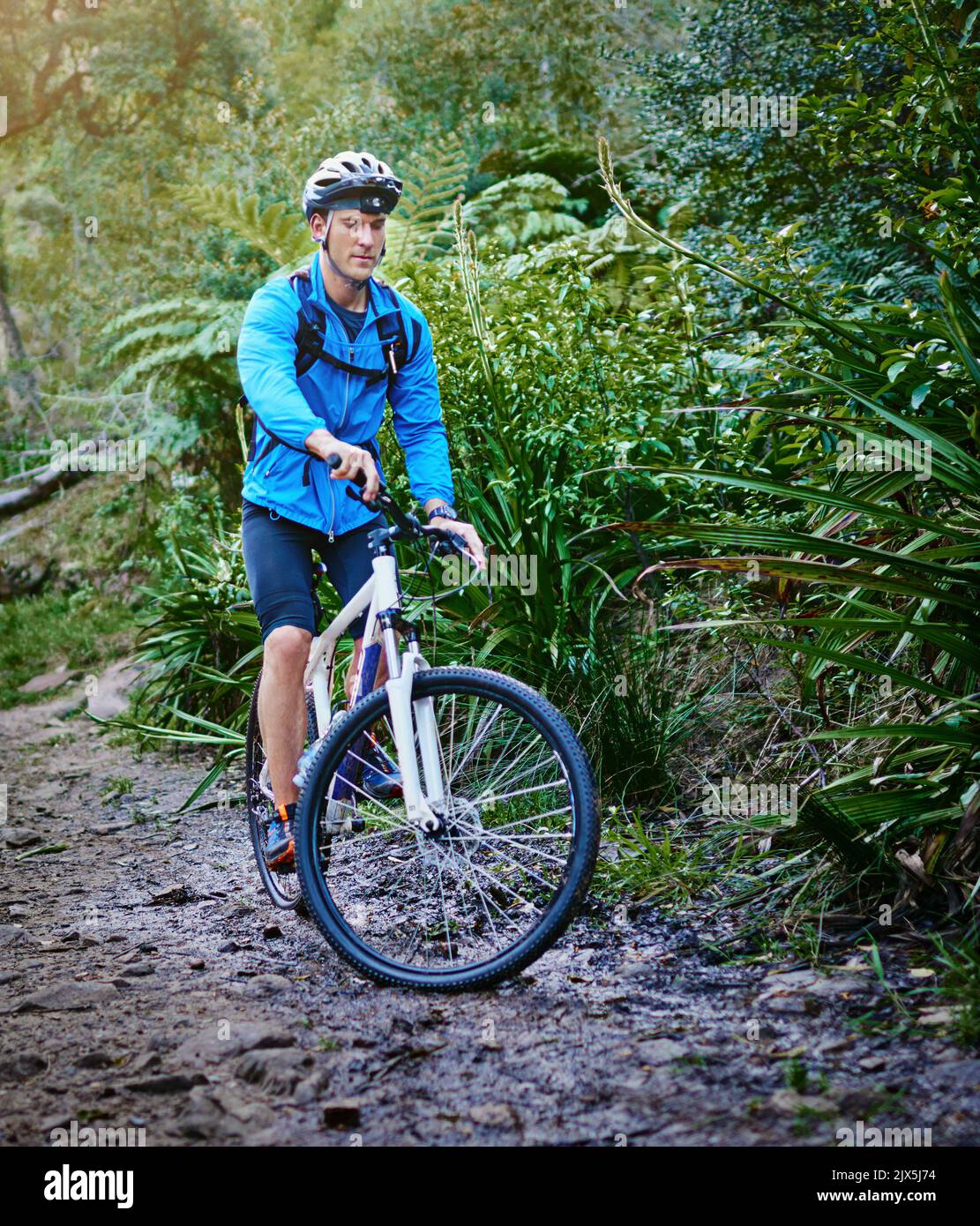Mountain biking- its what he does for fun. a male cyclist riding along ...