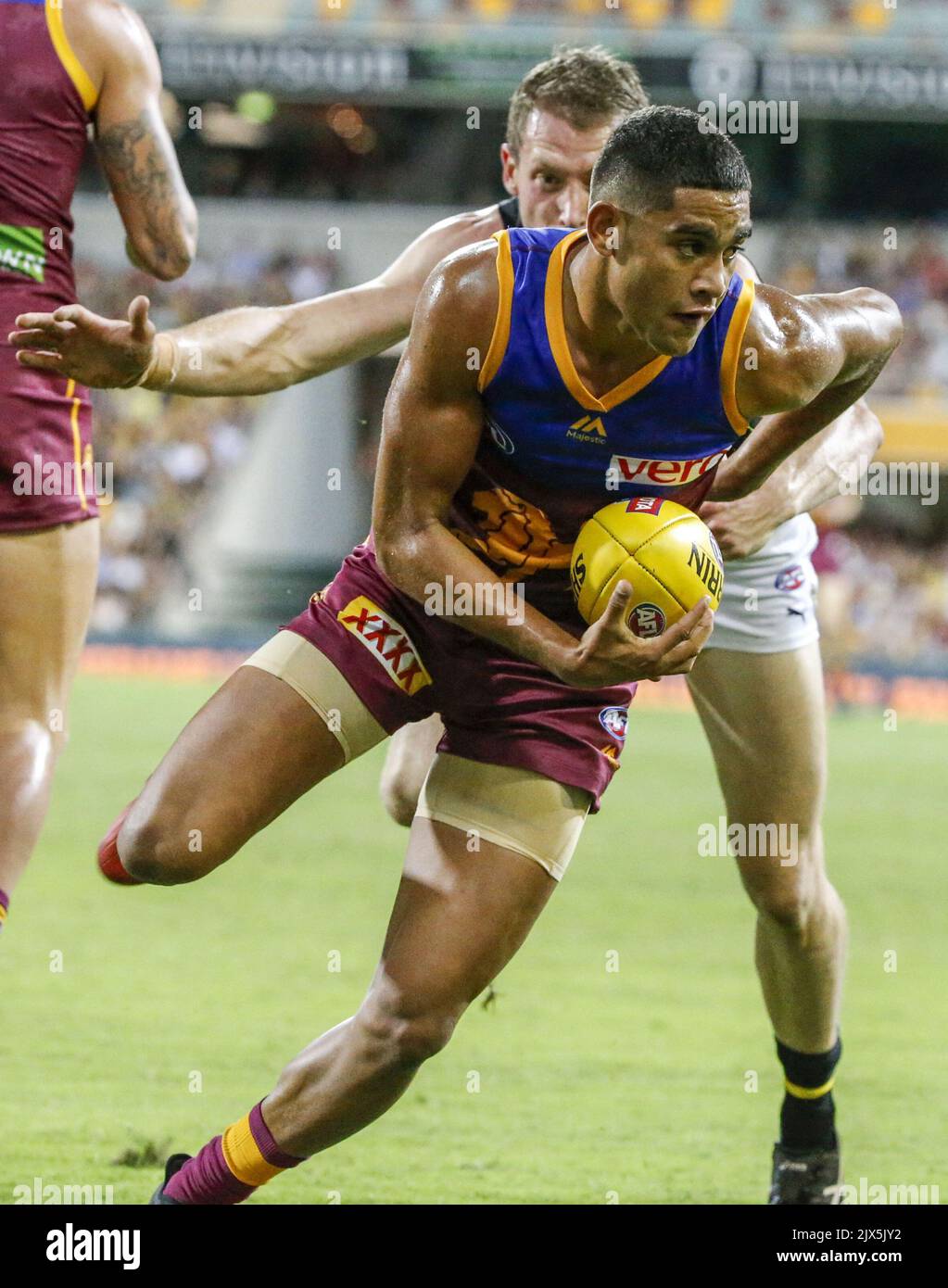 Cedric Cox of the Lions evades a tackle by Dylan Grimes of the Tigers ...