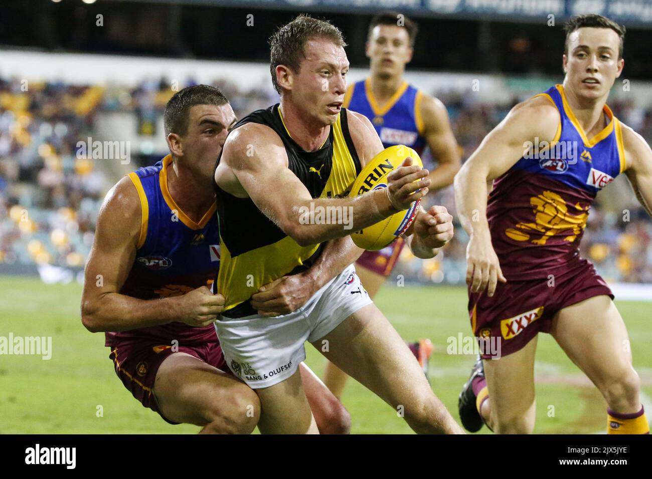 Dylan Grimes of the Tigers is tackled by Tom Rockliff of the Lions ...