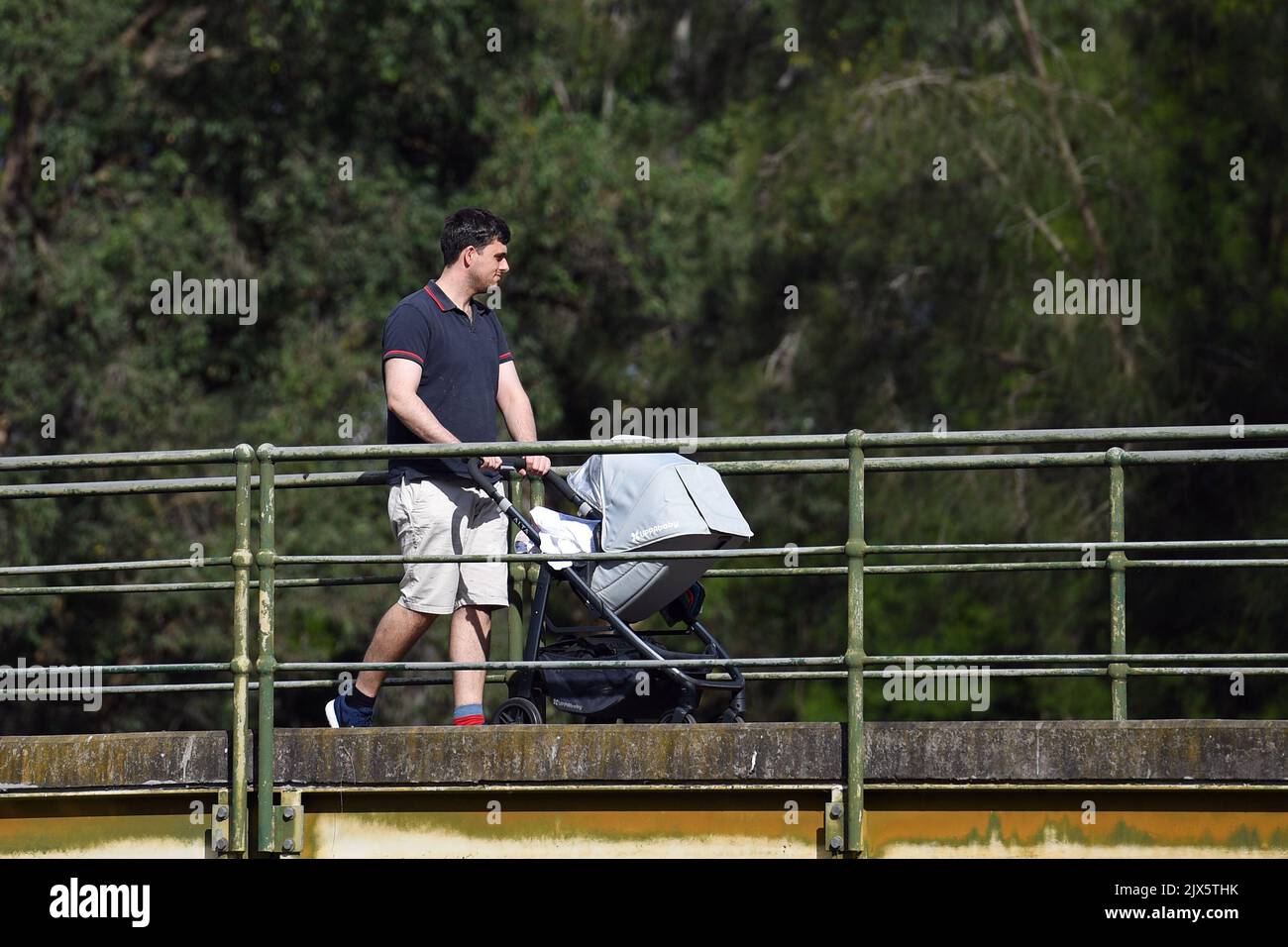 A man pushing a pram walks through a park in Sydney on Sunday, April 30 ...