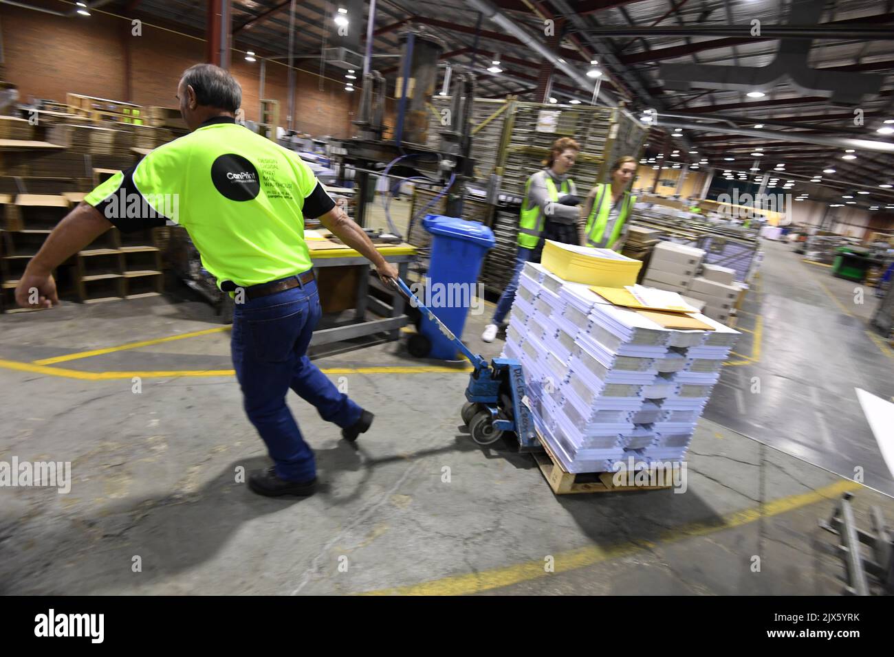 A man moves a stack of the Budget papers at Canprint in Canberra ...
