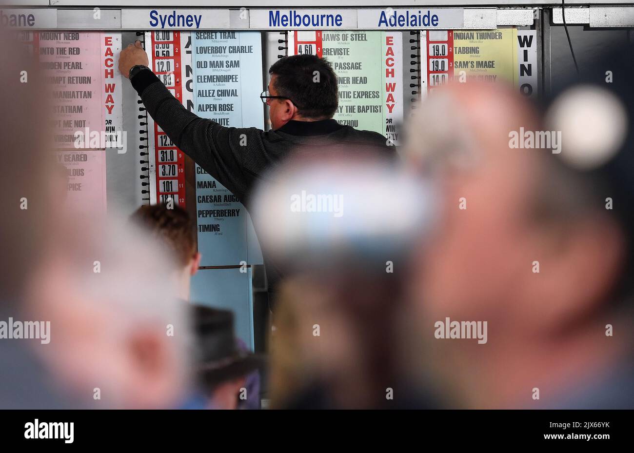 A bookie changes his odds during the Doomben Cup Day at Doomben ...
