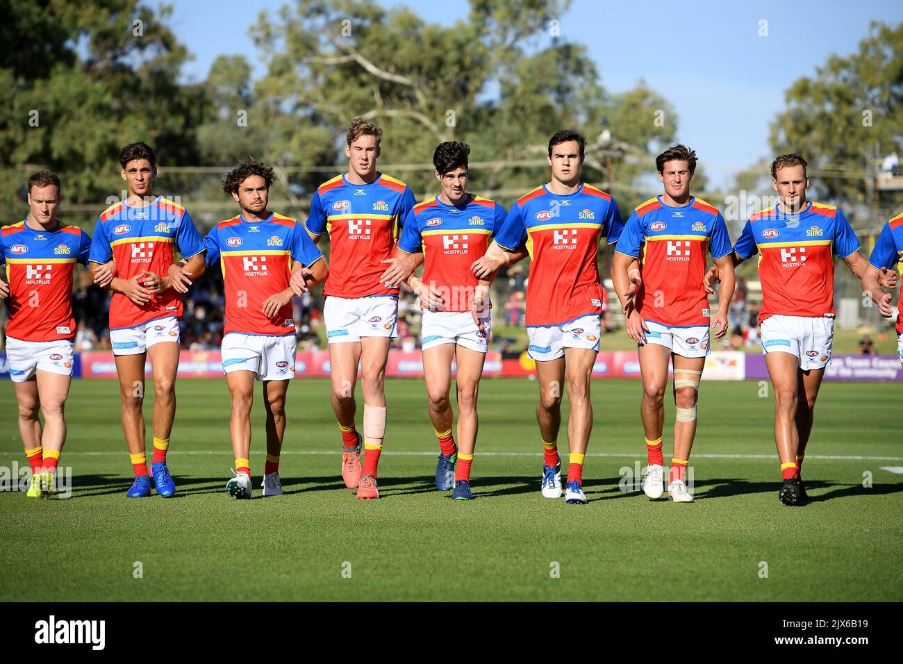 Gold Coast Suns players link arms in a gesture to support an end to ...