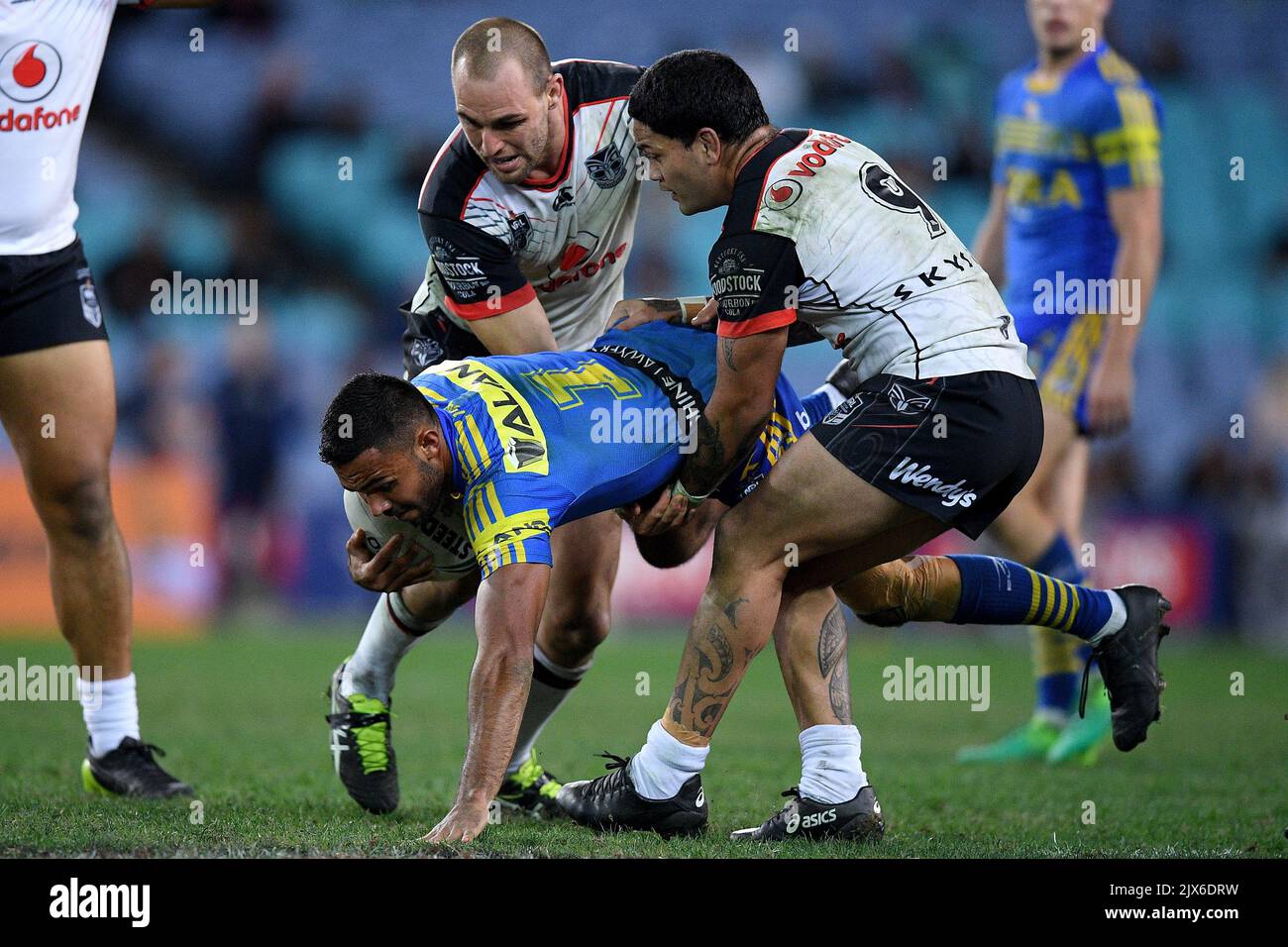 Bevan French of the Eels is tackled by Simon Mannering, (left), and ...