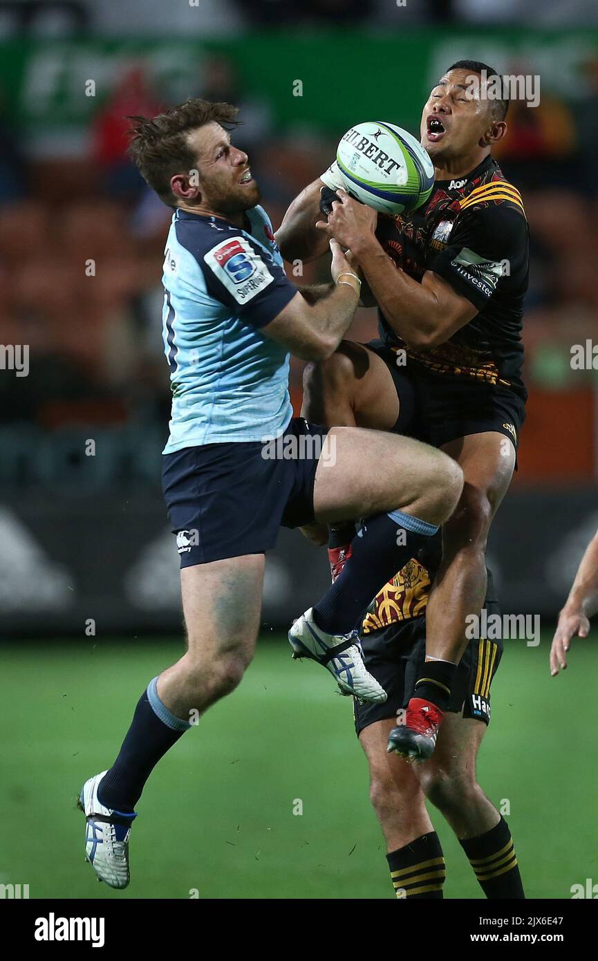 Bernard Foley of the Waratahs and Toni Pulu of the Chiefs clash over a ...