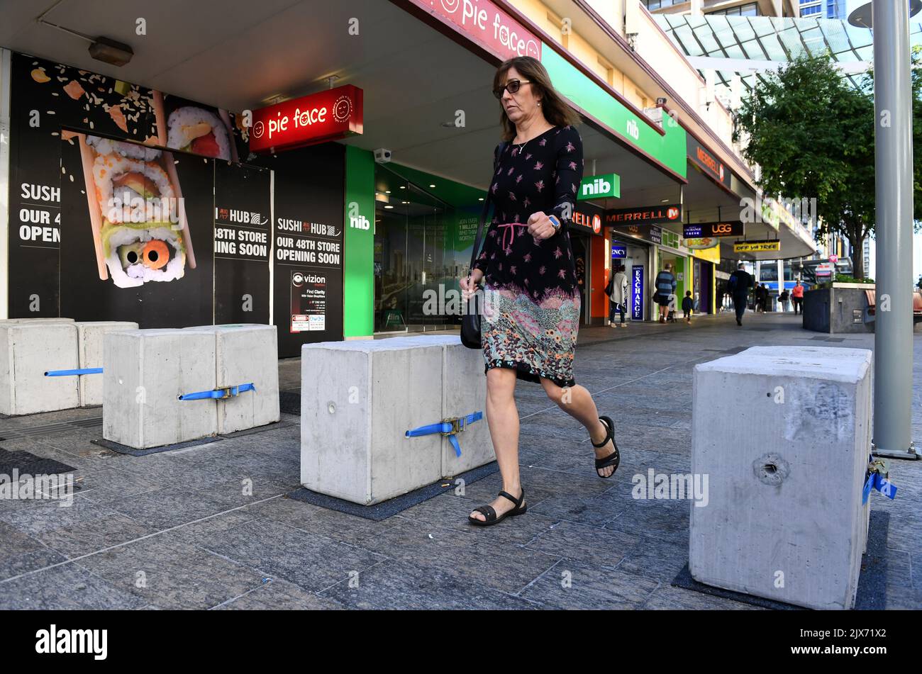 Workers install concrete bollards at the entrance to Queen Street mall ...